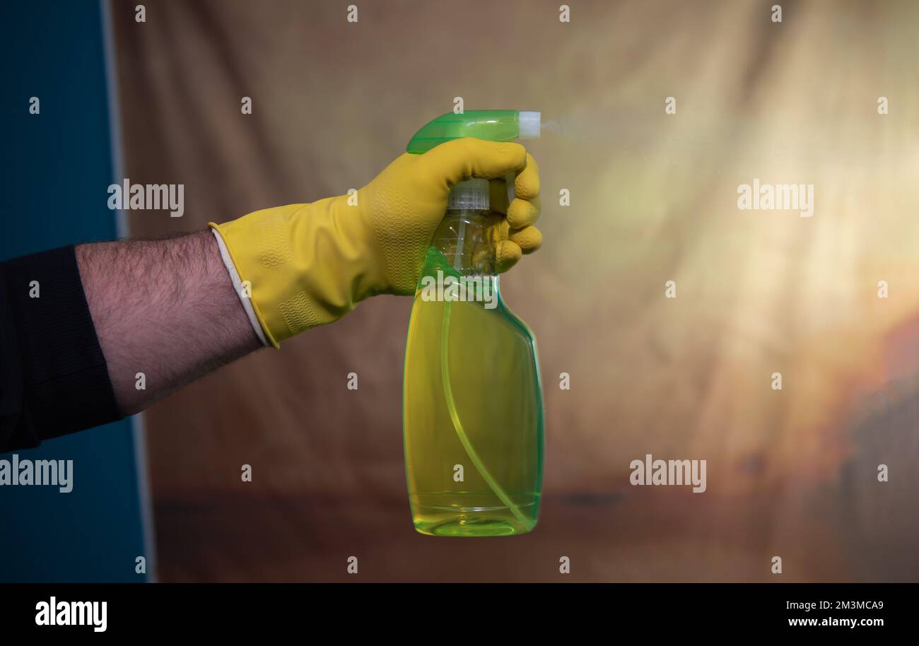Cleaning dirty surfaces with a cleaning agent. Hand in a rubber glove ...