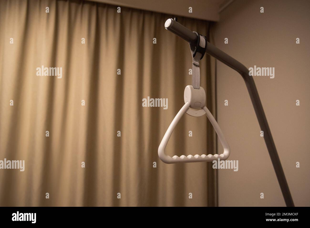 Hospital bed pull-up device. room with brown curtains Stock Photo - Alamy