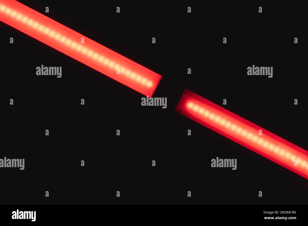 Red neon lights diagonally embedded in the asphalt. Abstract texture ...