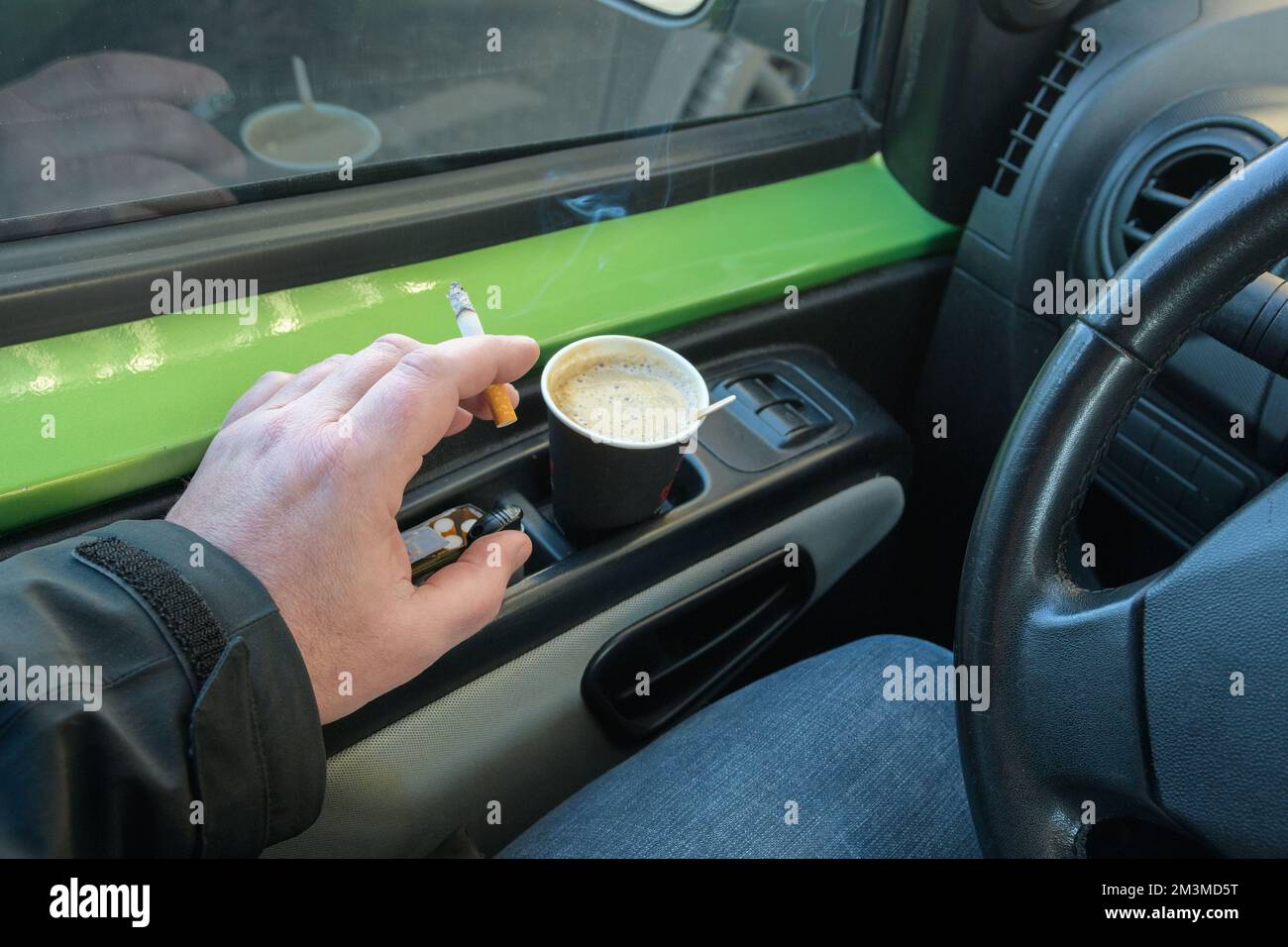 Driving a car while smoking. holding a cigarette. Paper disposable ...