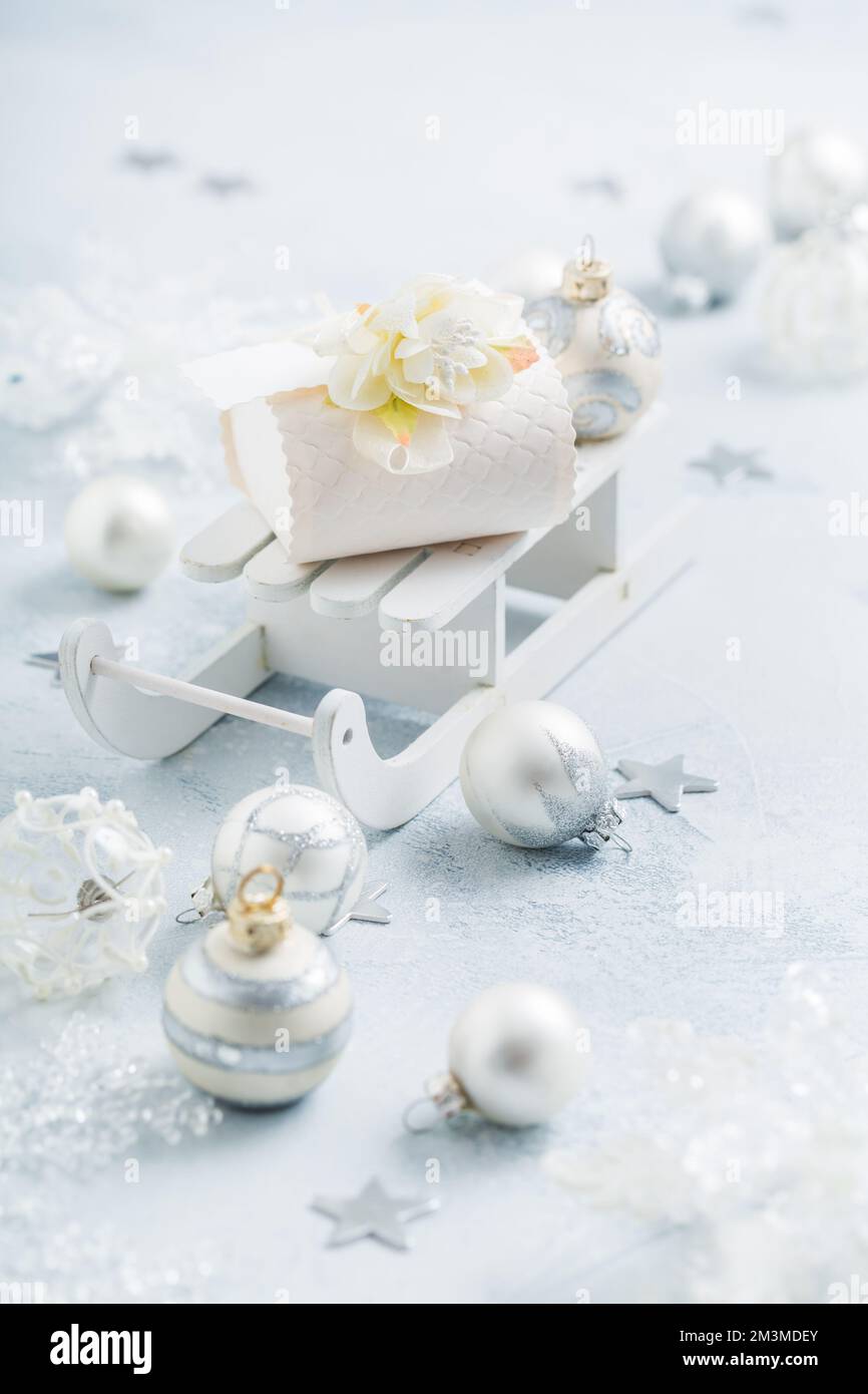 Christmas ornaments, balls and small present box on sledge in silver ...