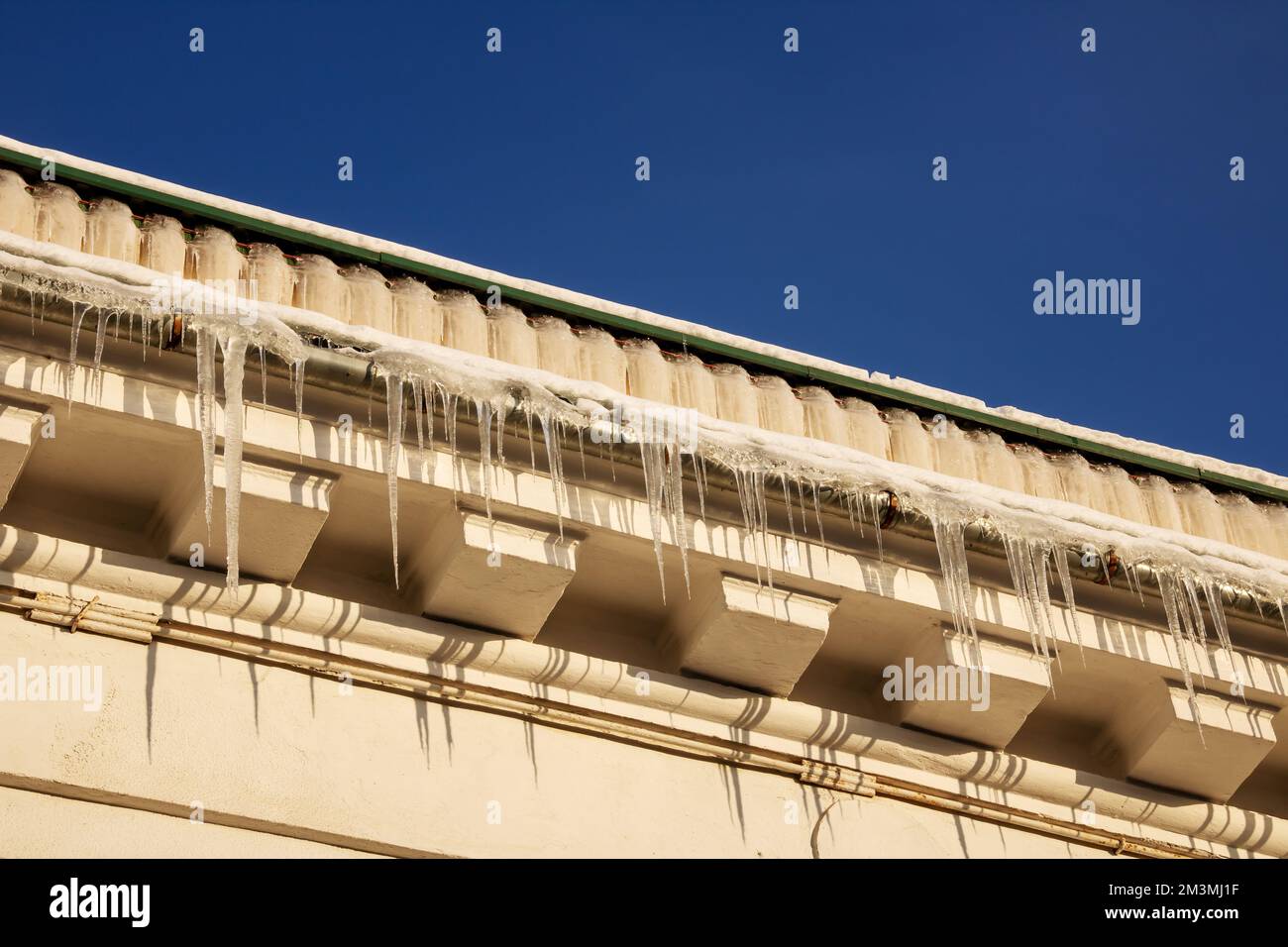 Large icicles on the roof edge close up Stock Photo - Alamy