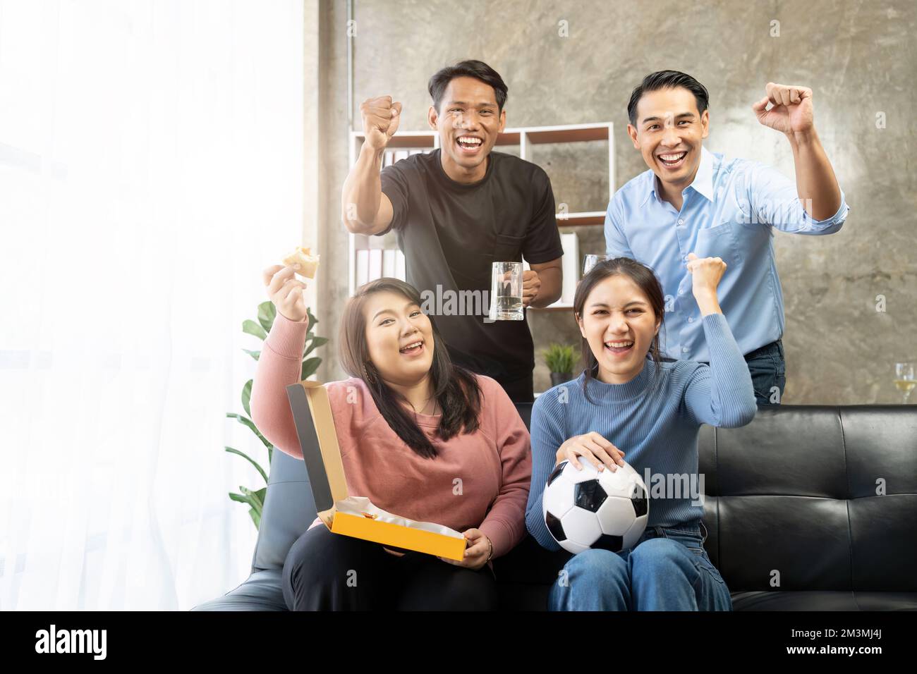 Friends watch sports on TV, cheer and celebrate. Happy diverse asian ...