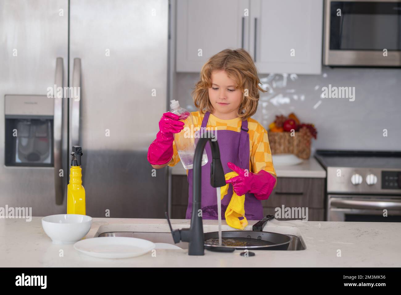 Cleaning house. Portrait of child cleaning in the kithen at home ...