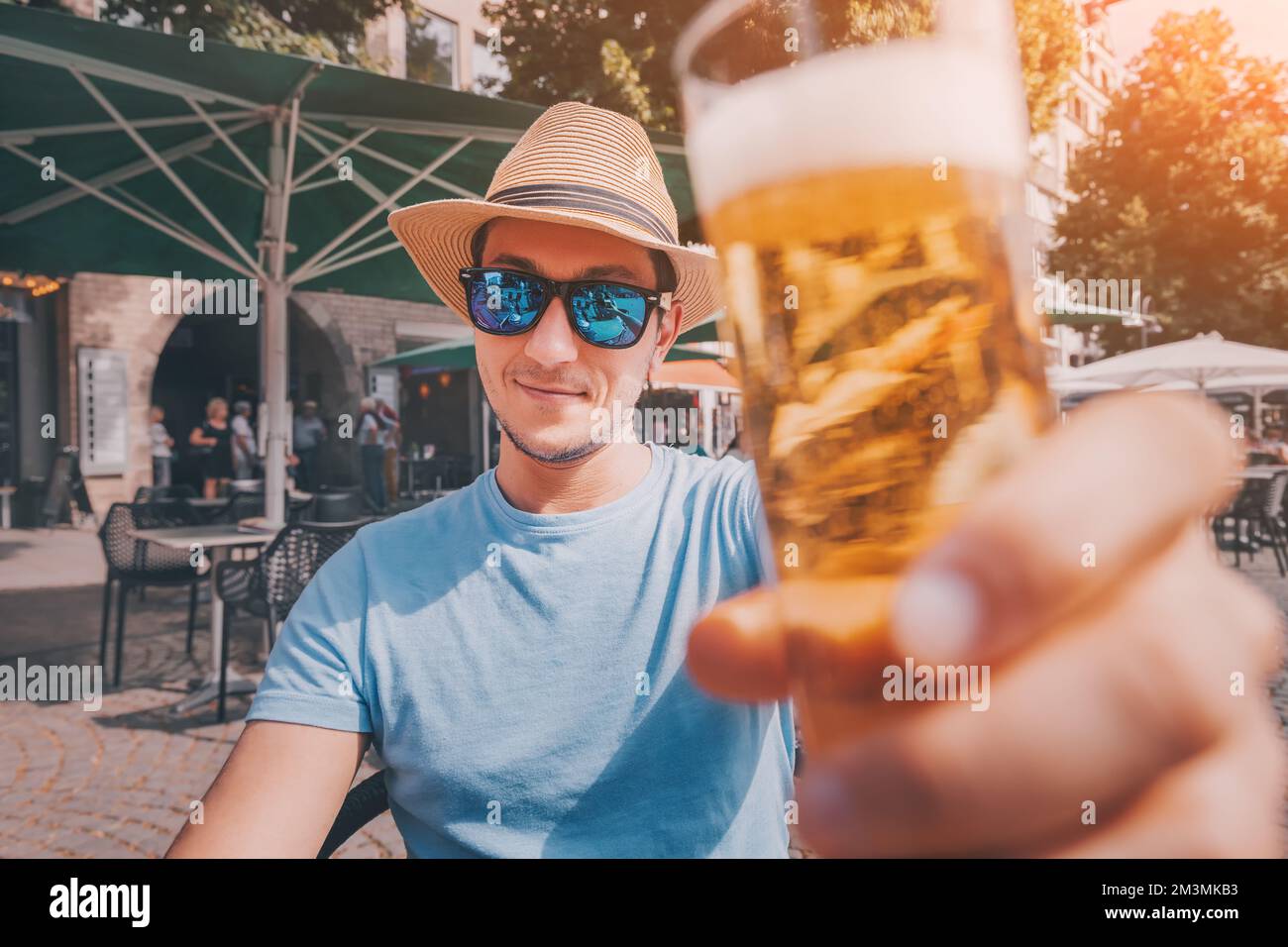 Tourist happy man wearing sunglasses and hat tasting and drinking ...