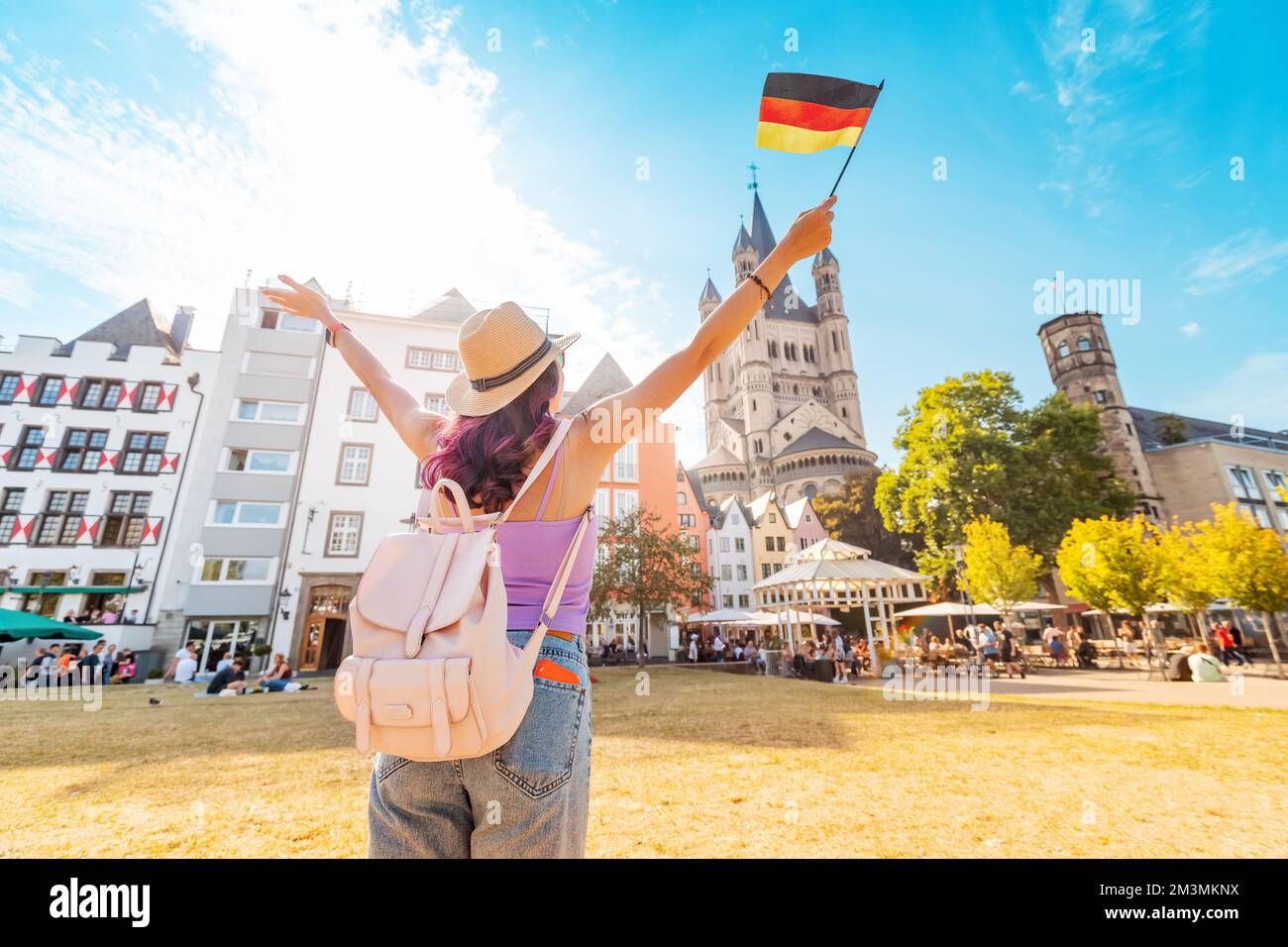 A young happy tourist or student girl with a German flag at the old ...