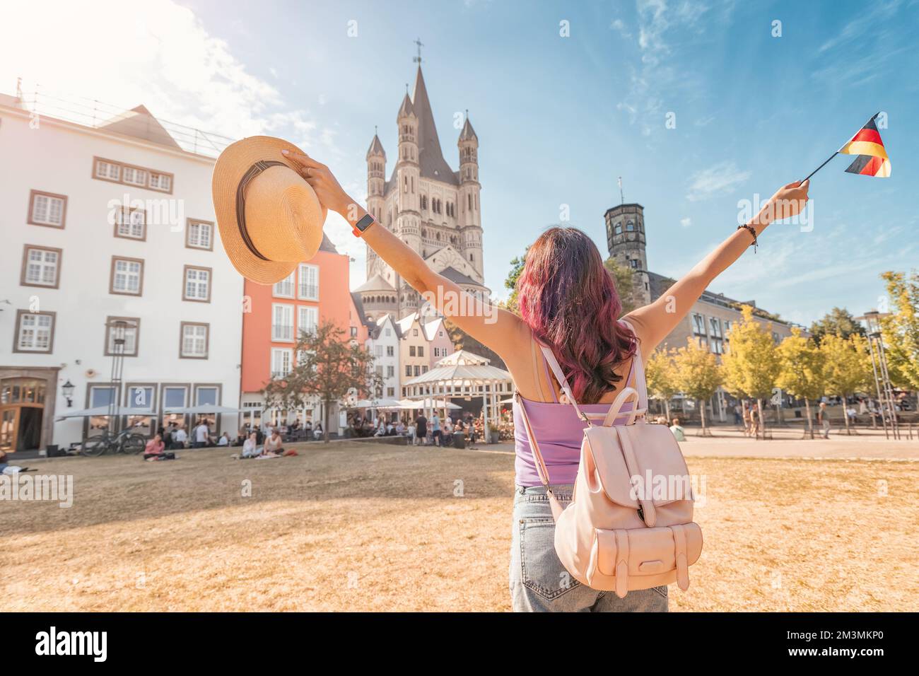 A young happy tourist or student girl with a German flag at the old ...