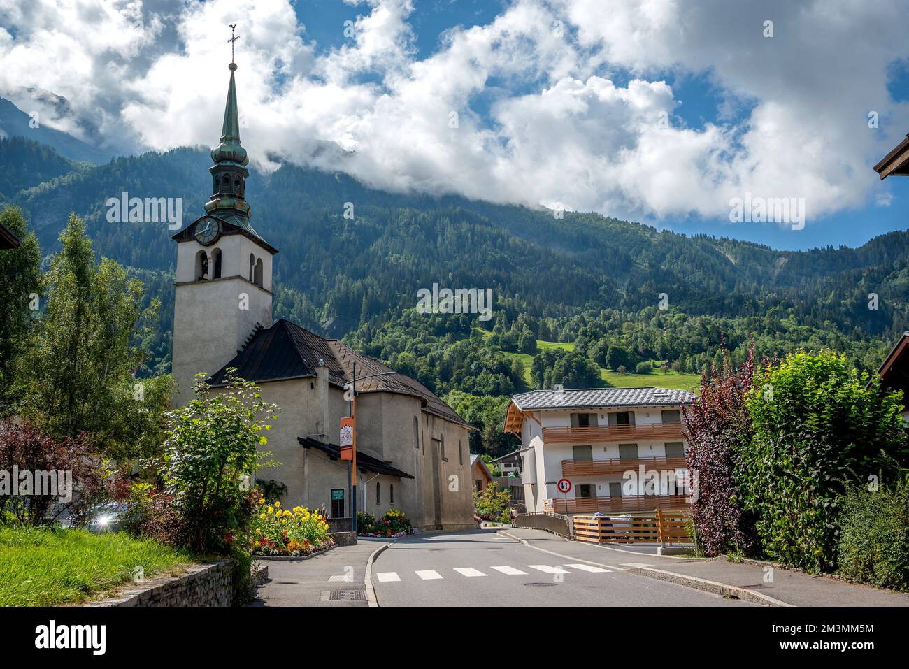 A scenic shot of a church in Switzerland with green-covered hills on ...