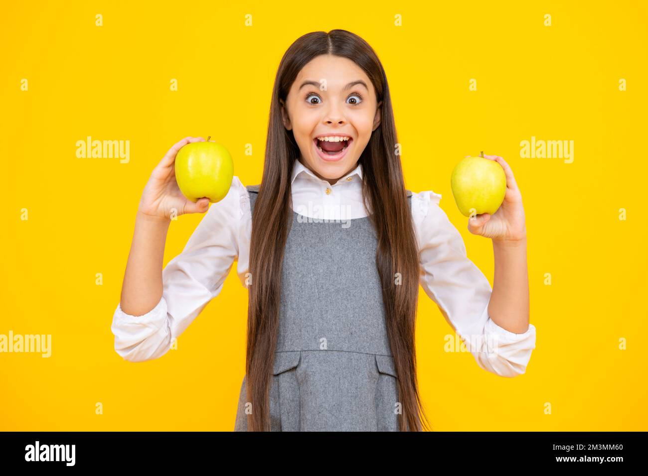 Teenager child girl biting tasty green apple. Excited face. Amazed ...