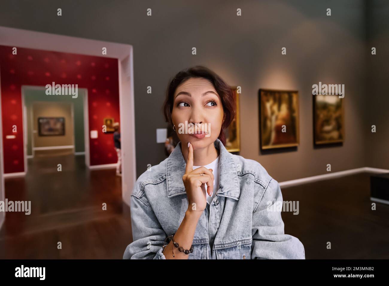 A girl critic and expert visitor to a museum or art gallery ...