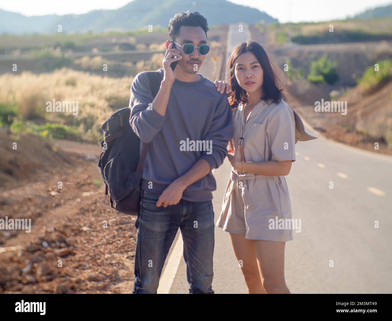 A man carrying a bag and talking on the phone and standing on the ...
