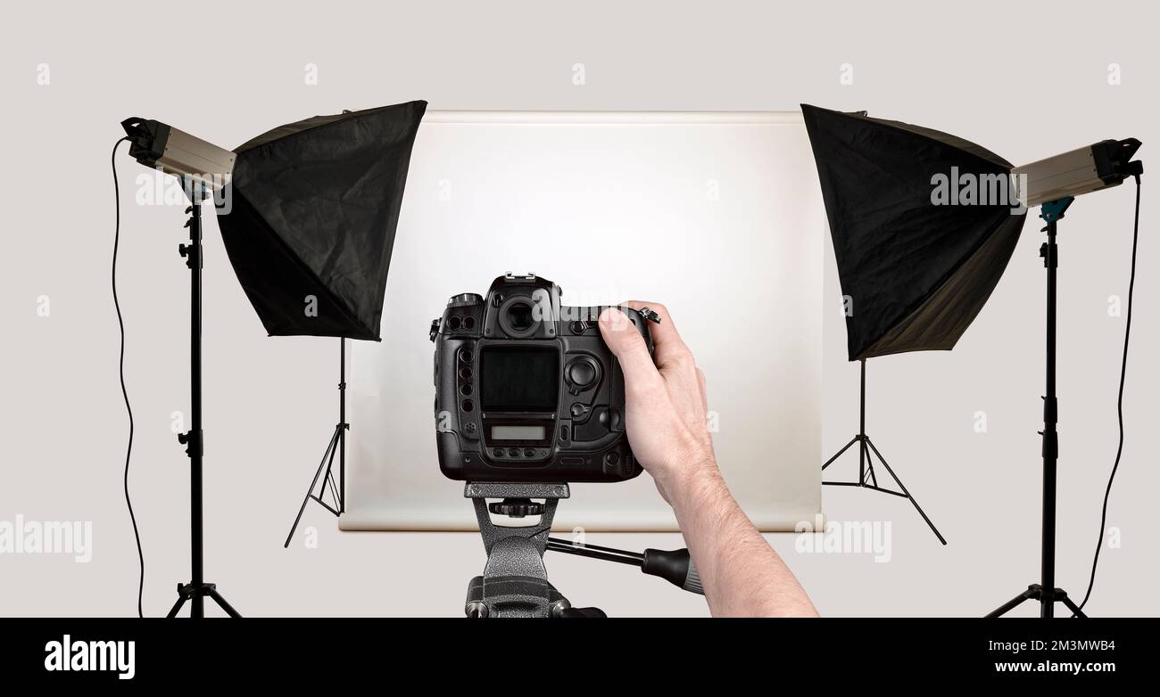 Male hand shoot with black camera in photo studio. Isolated with ...