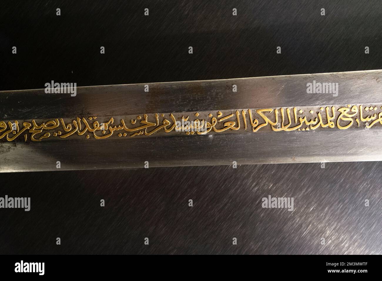 A closeup of a sword surface with Arabic calligraphy isolated on a ...