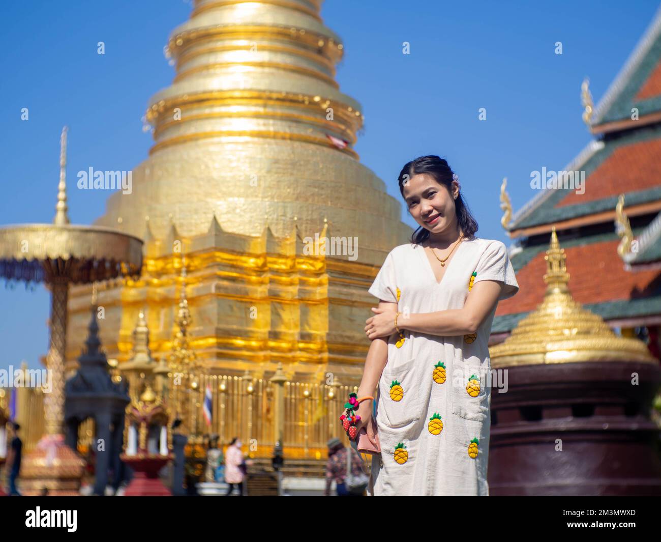A woman standing inside a temple with a pagoda behind Stock Photo - Alamy