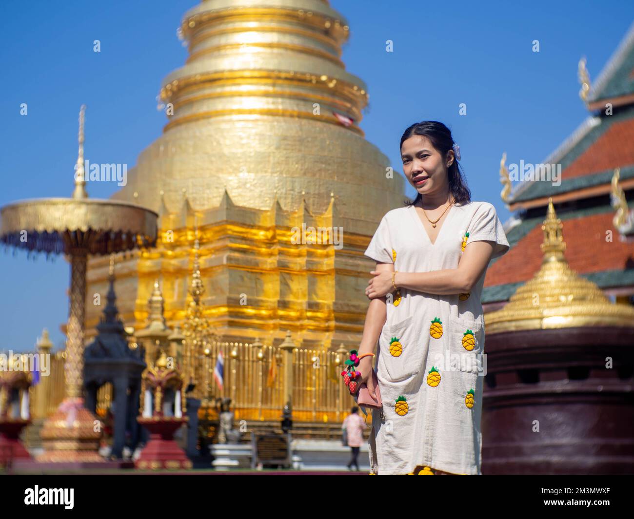 A woman standing inside a temple with a pagoda behind Stock Photo - Alamy