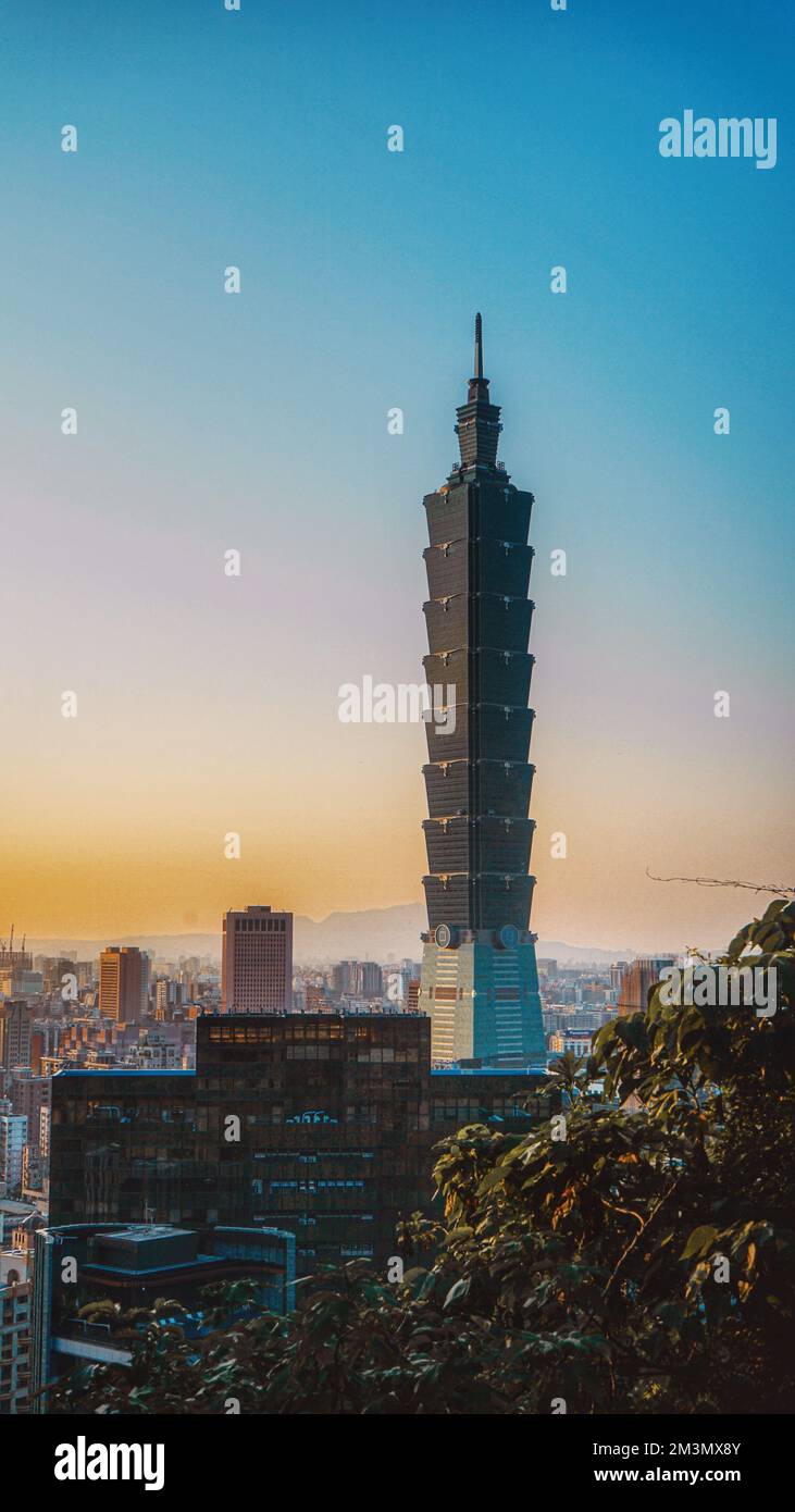 A vertical aerial view of Taipei 101 Shopping center tower on sunset ...