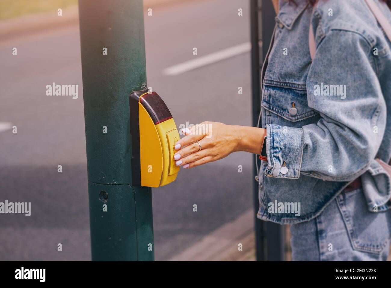 Aware pedestrian presses the traffic light control button to safely ...