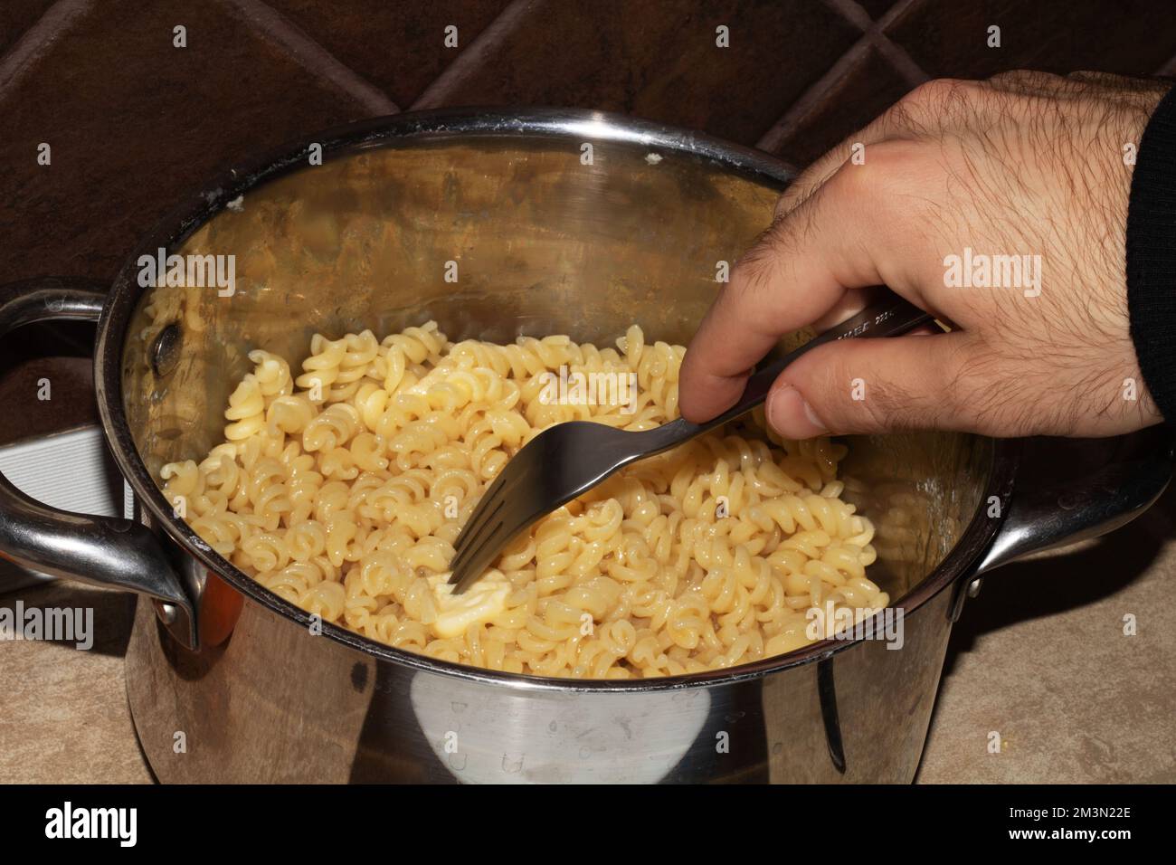 photo hot spiral shaped pasta with butter in a saucepan Stock Photo - Alamy