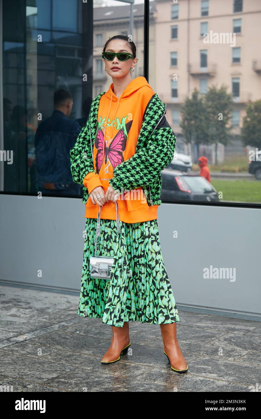 MILAN, ITALY - SEPTEMBER 24, 2022: Woman with orange MSGM hoodie with butterfly and houndstooth ...