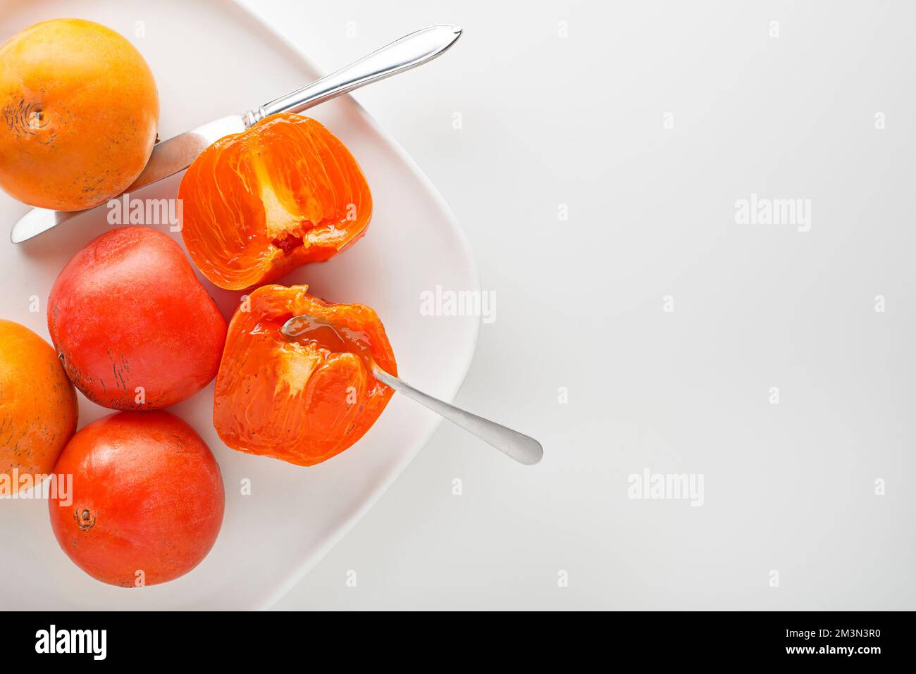 Ripe red and yellow orange persimmon fruit.Slices of persimmon. Close ...
