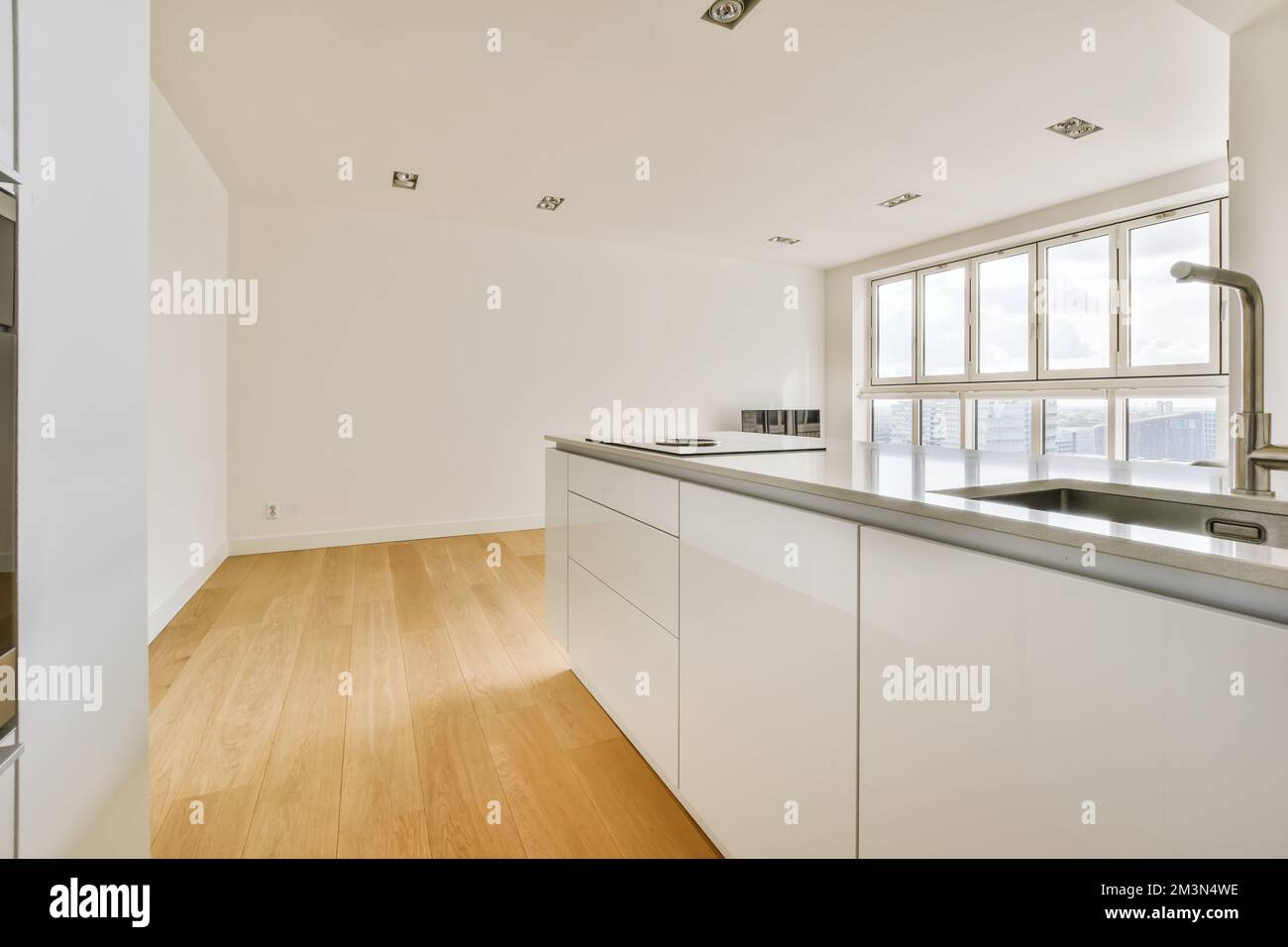 a kitchen with wood flooring and an oven in the center of the photo is ...