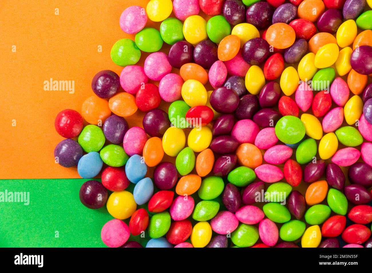 An overhead shot of sweet candies on the colorful surface Stock Photo ...