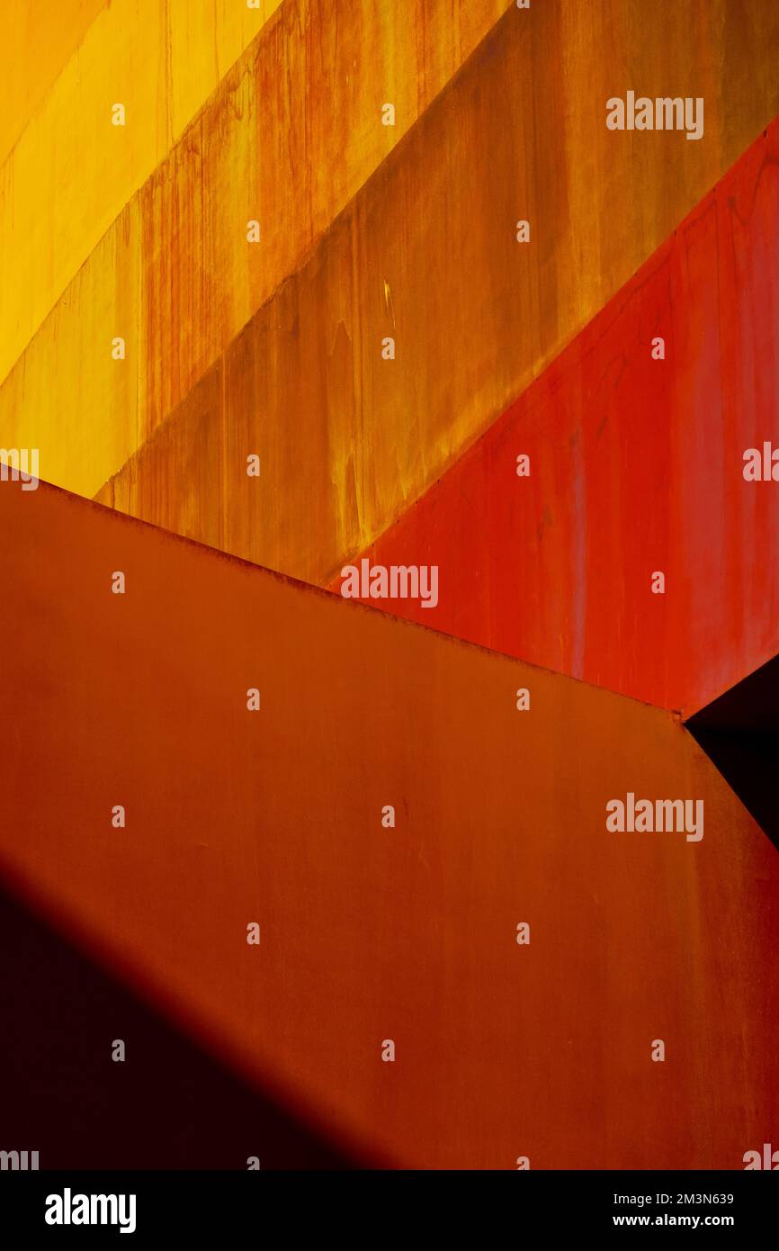 Low angle of bright orange wall of modern building illuminated with ...