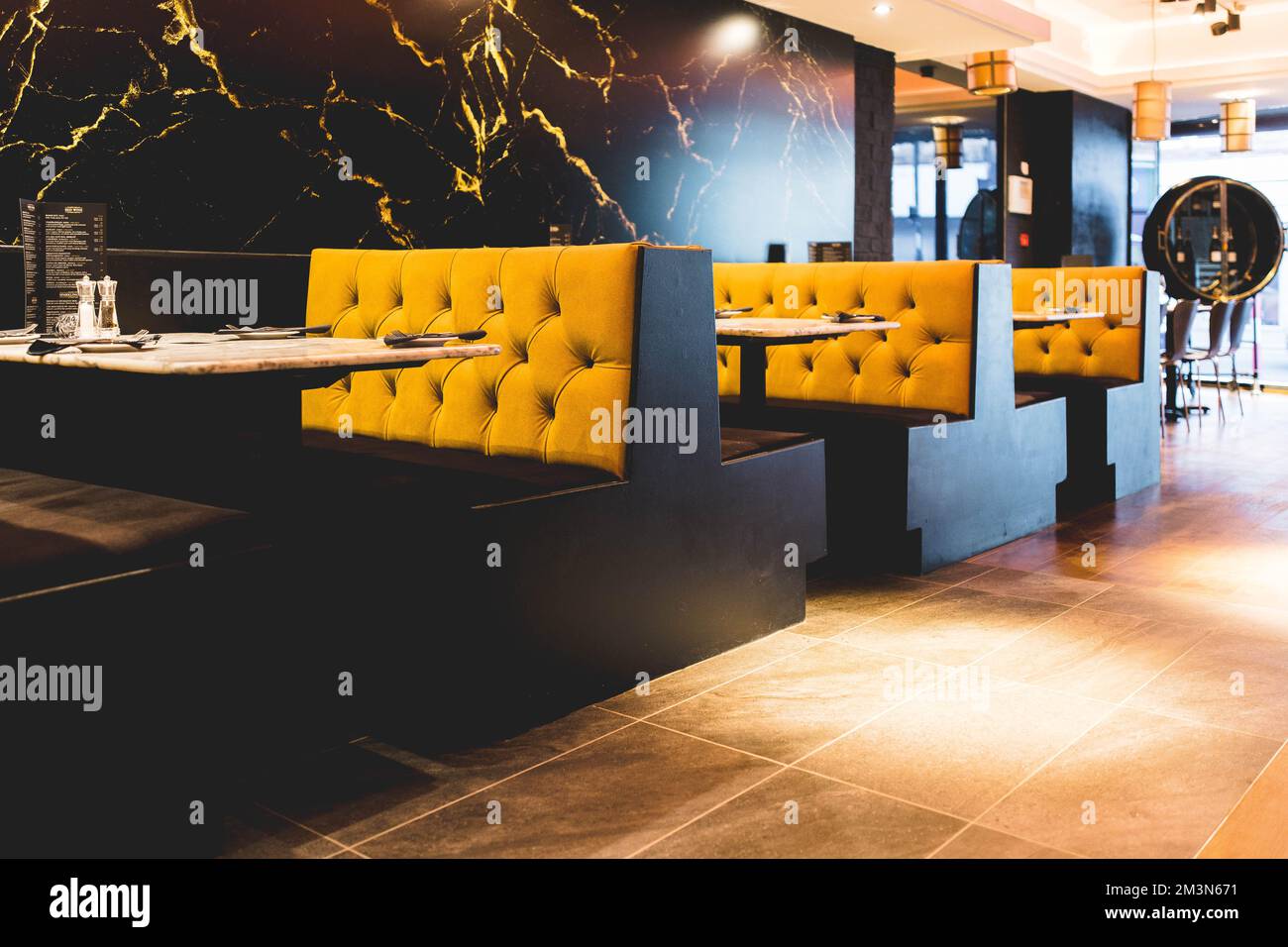 A restaurant interior with black walls and yellow chairs Stock Photo ...