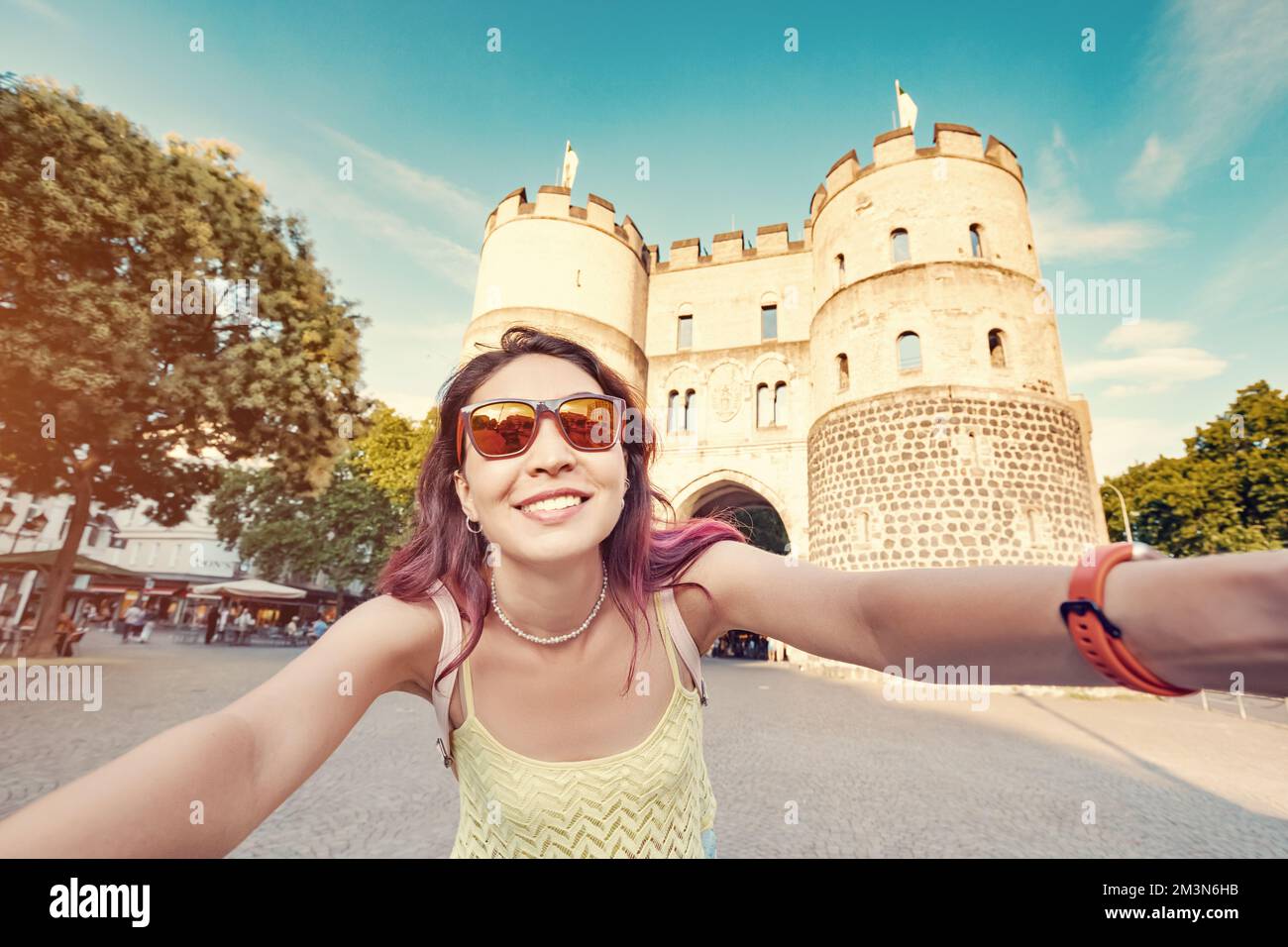 Tourist girl taking selfie wide angle photo with Romerturm gates as ...
