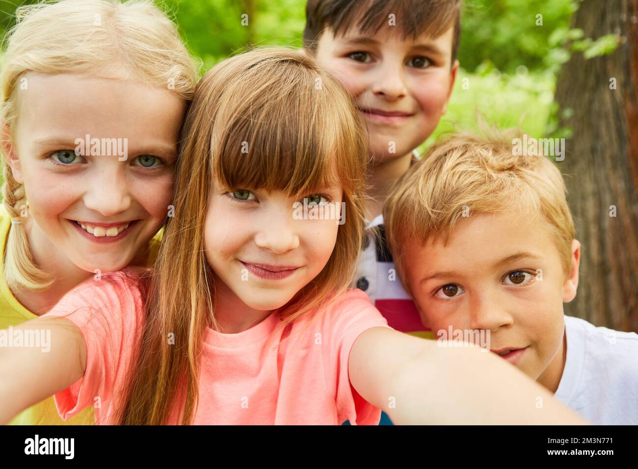 Happy group of children taking selfie photo with smartphone in nature ...