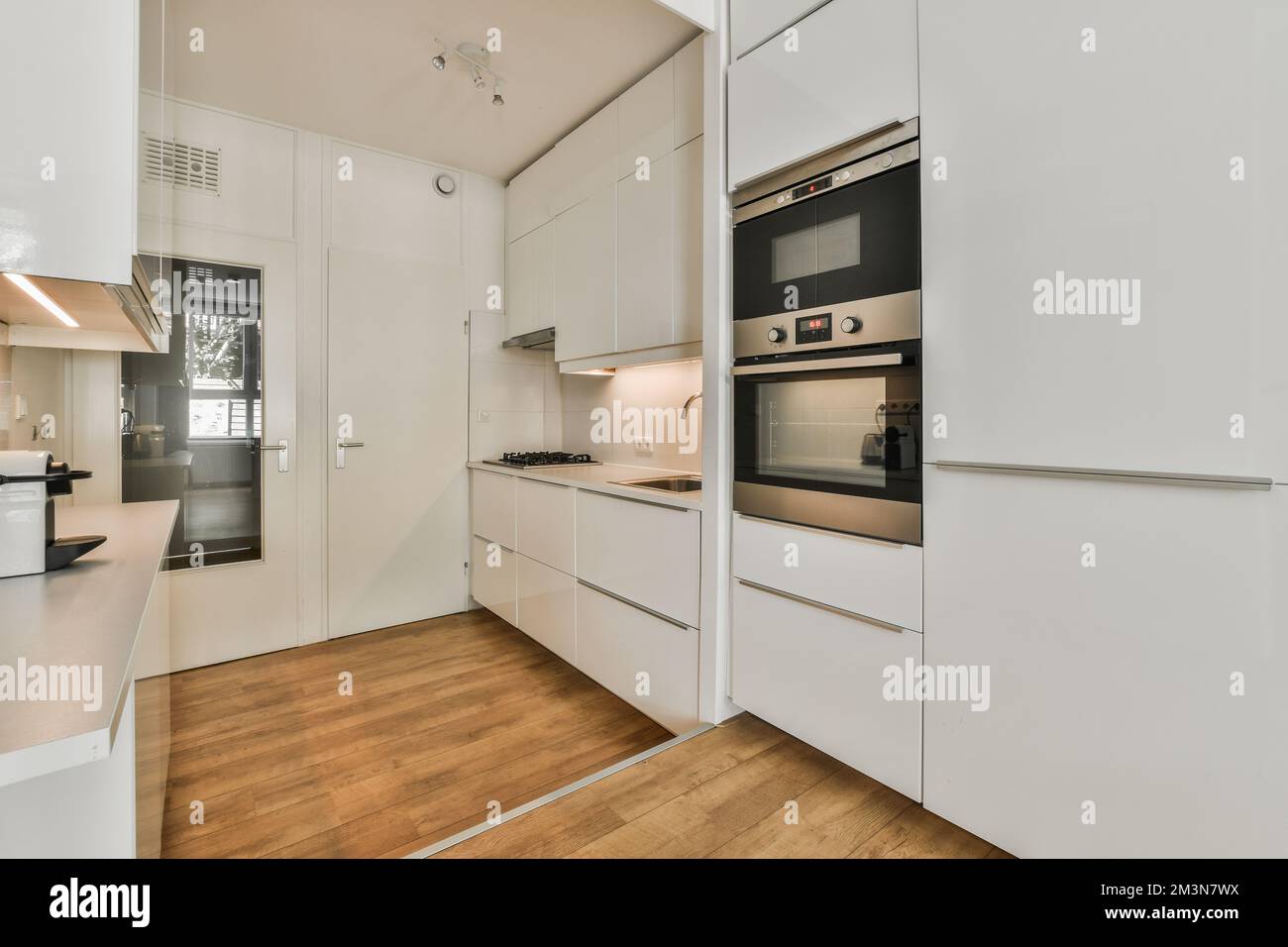 Table with chairs located near lounge area and kitchen in spacious room ...