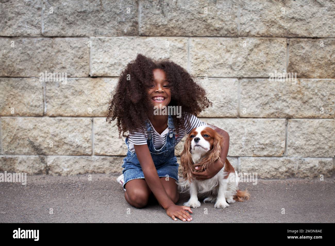 Smiling african american kid girl with dog outside. Happy child with ...