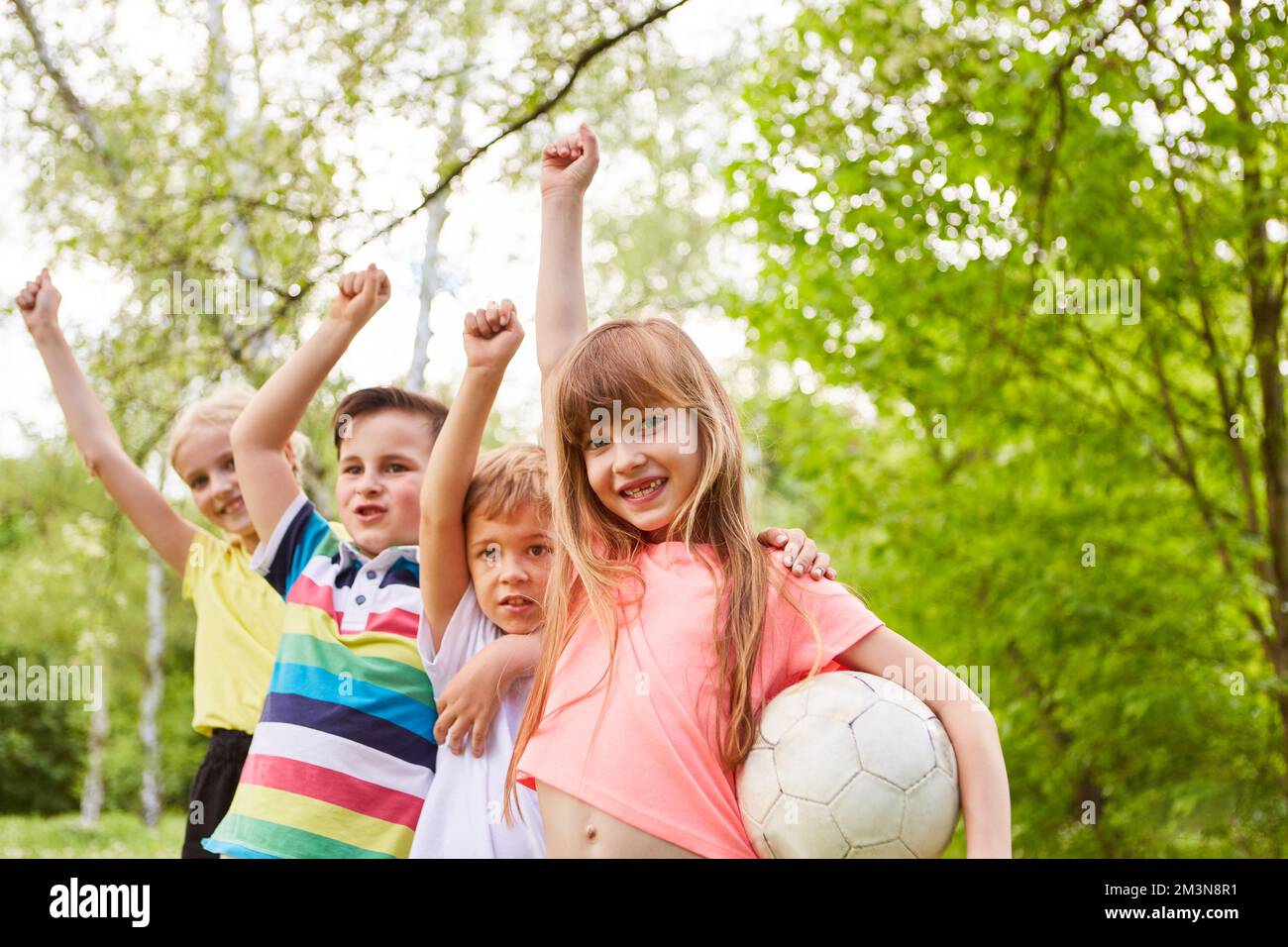 Group of kids cheering together after winning soccer game in park ...