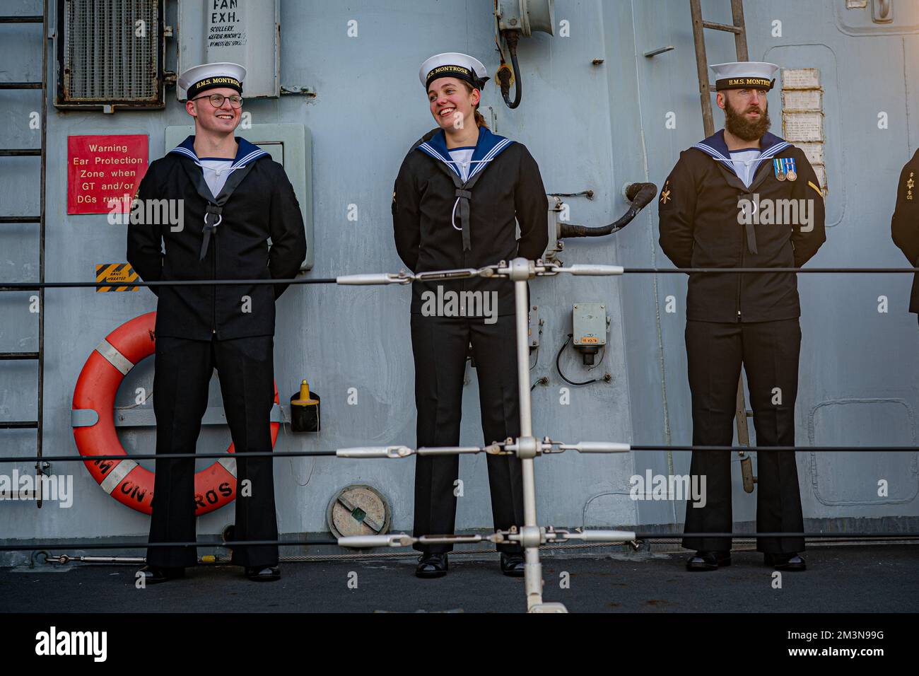 Sailors watch the crowds from the ship's deck as families and loved ...