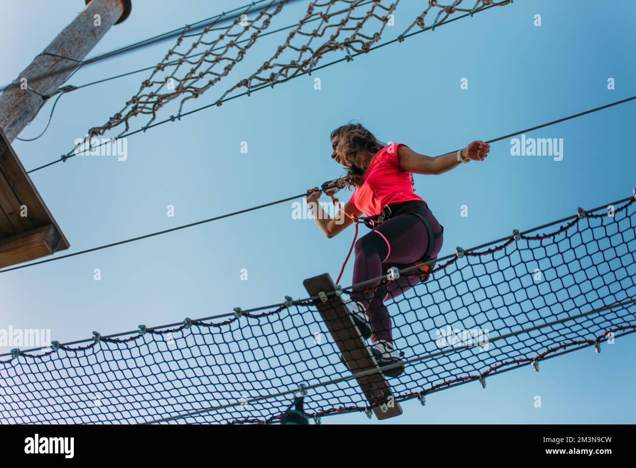 Young high schooler hanging onto the safety ropes and trying not to ...