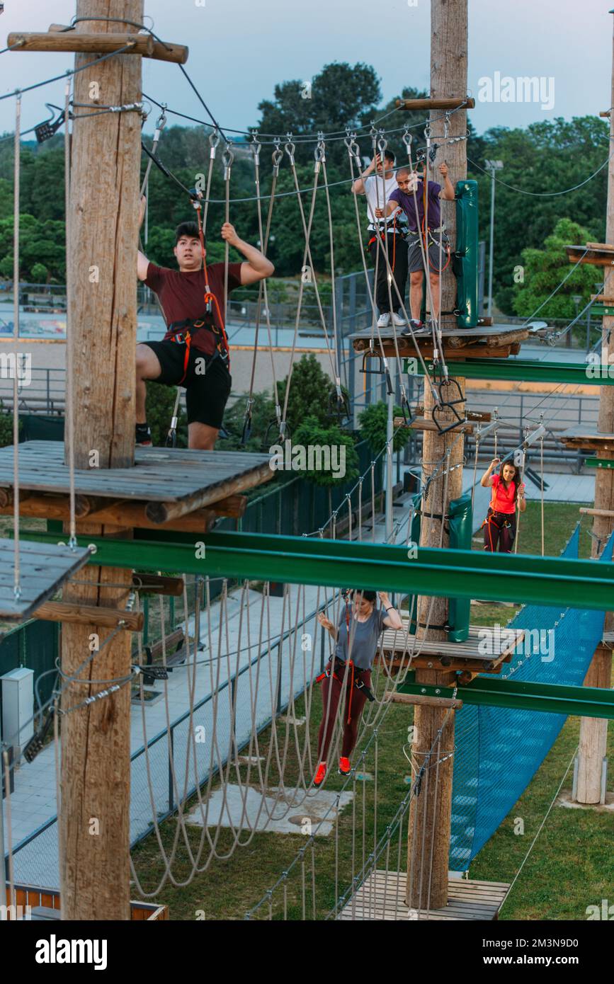 Adventure people on different levels climbing walking on the rope at ...