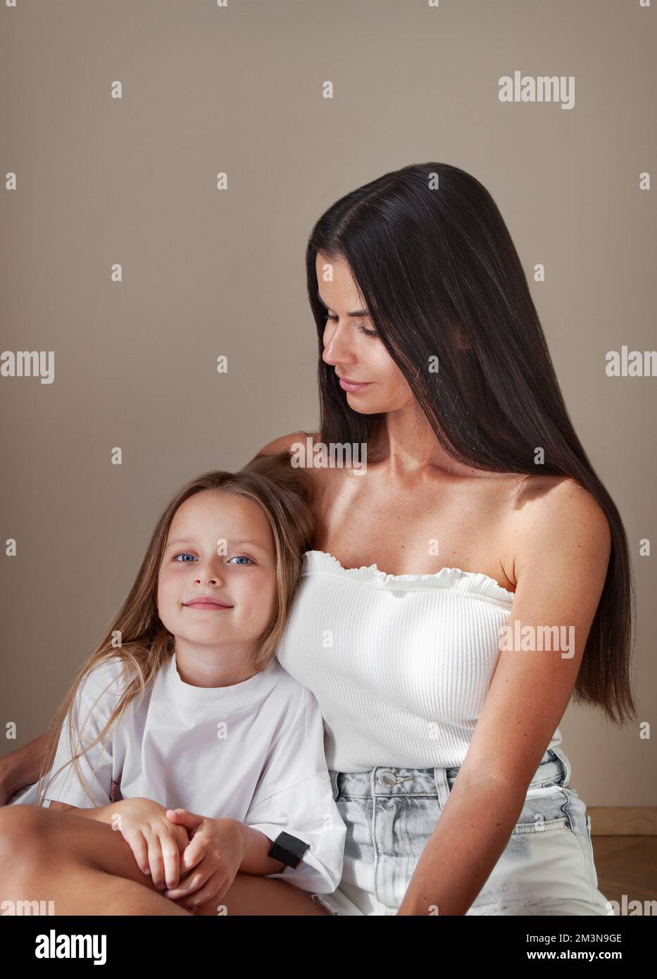 Mother and daughter. Portrait beautiful mom embrace girl in white ...