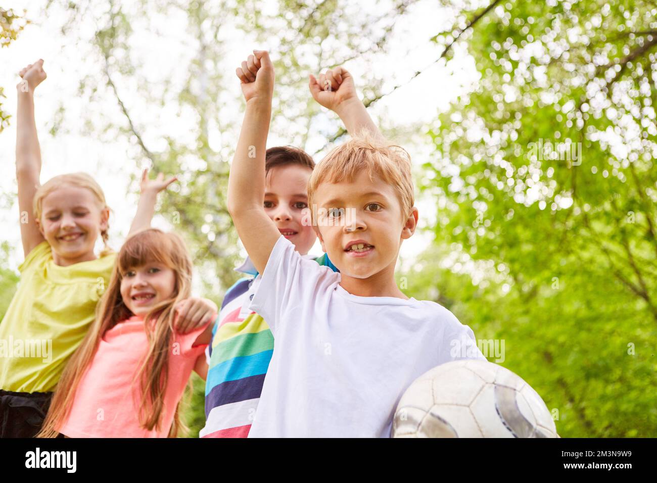Portrait of children cheering together after winning football game in ...