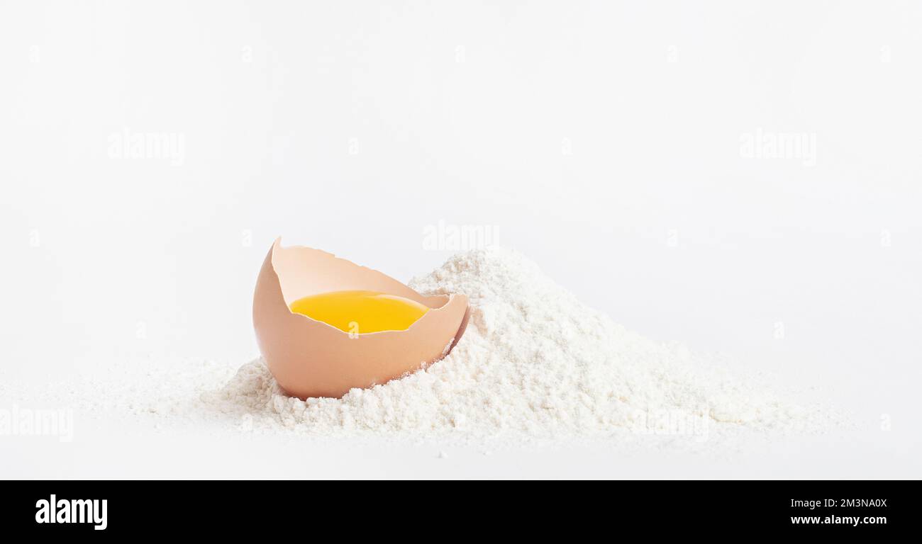 egg yolk in a shell on flour on a light gray background Stock Photo - Alamy