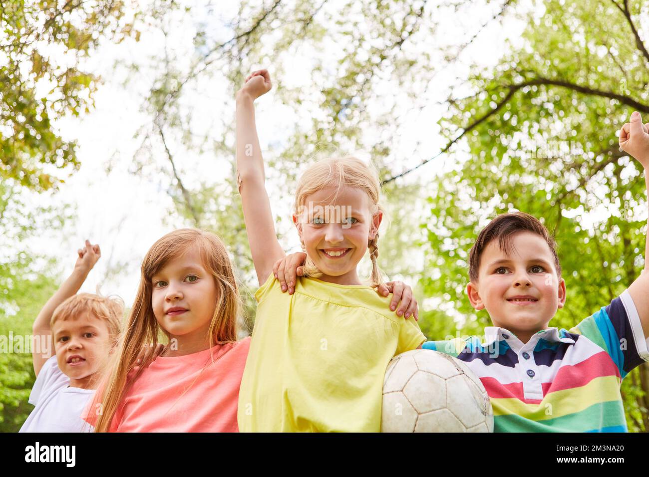 Group of kids cheering together after winning a soccer game in nature ...