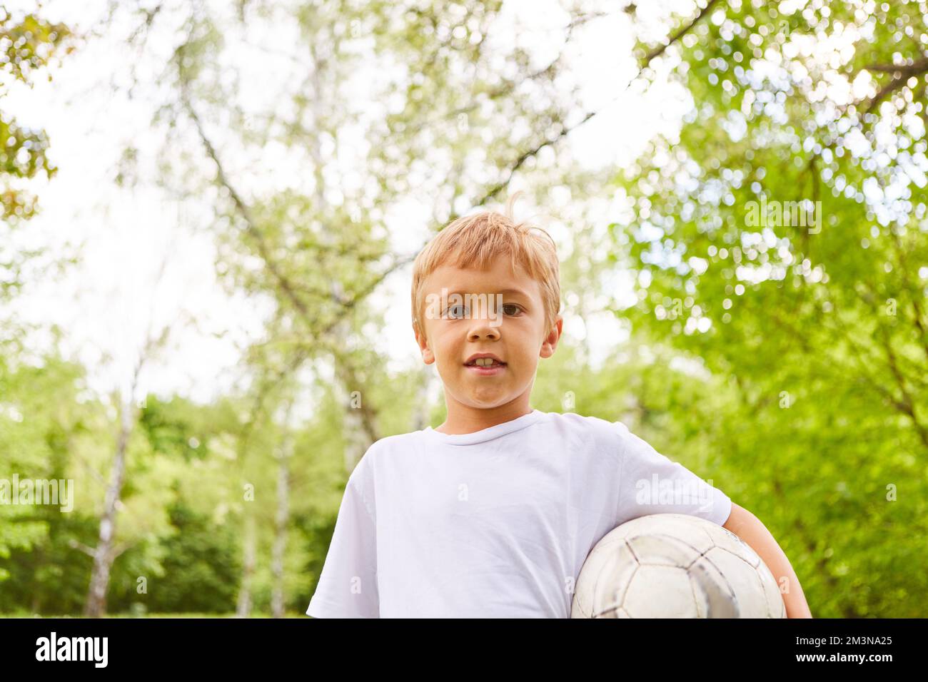 Boy carrying soccer ball in hi-res stock photography and images - Alamy