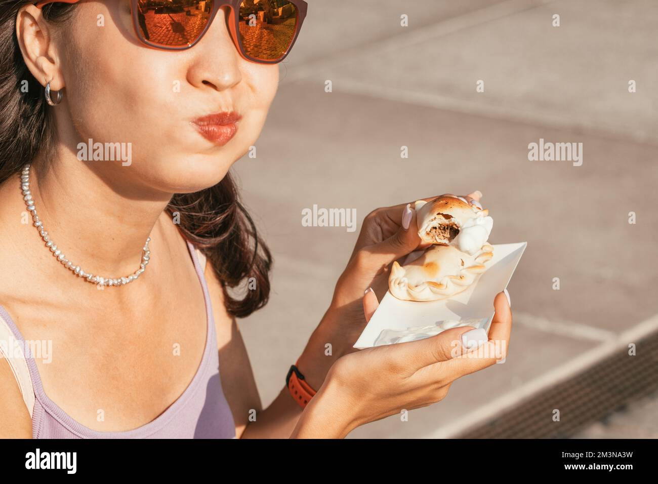 Girl chewing funny and eating delicious pies with empanadas filling ...