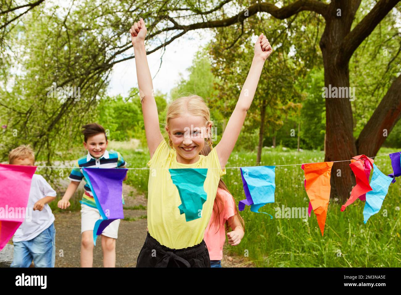 Portrait of cheerful girl winning race competition with friends in ...