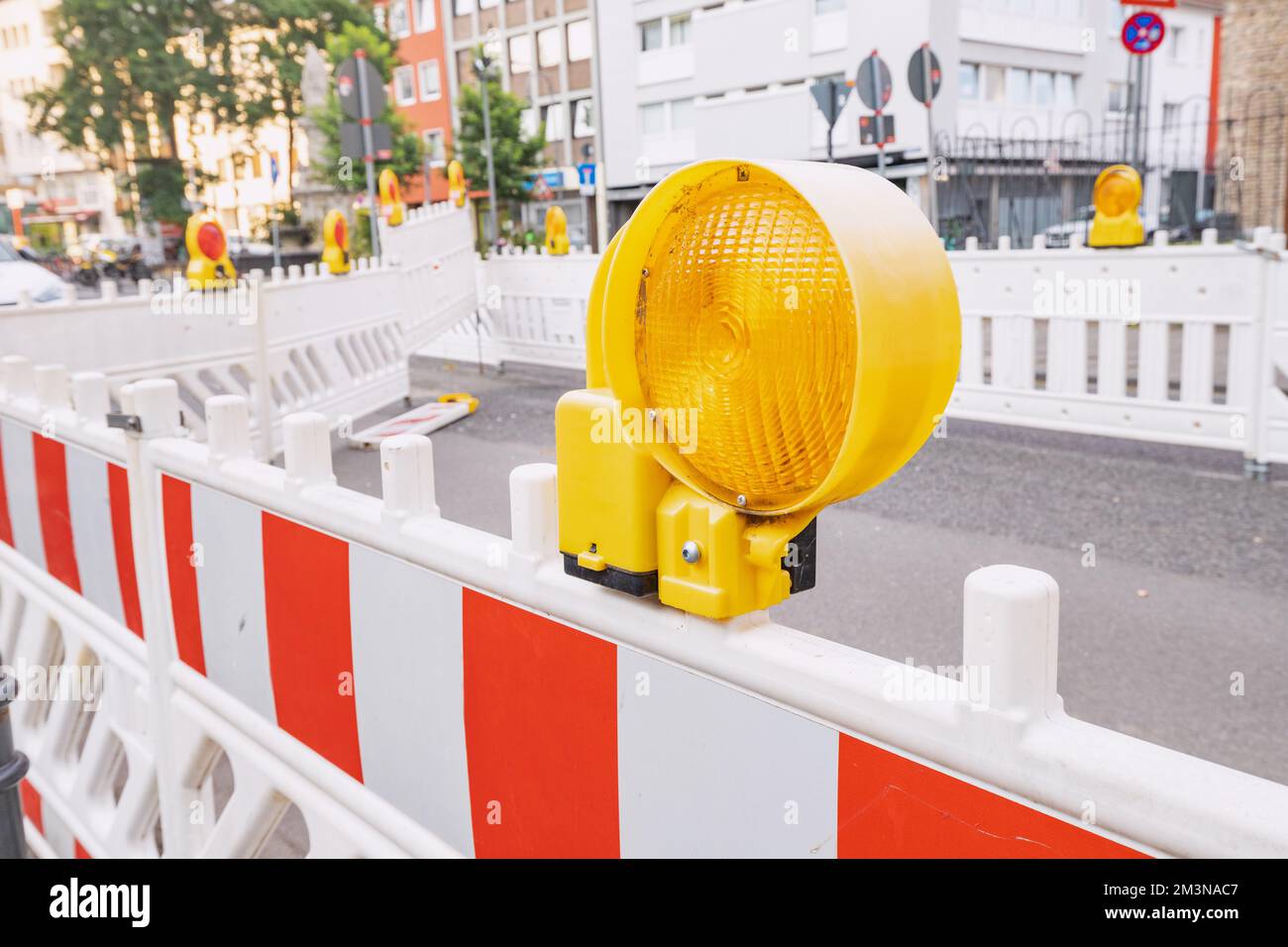 Road fence blocked for reconstruction with warning light at city street ...