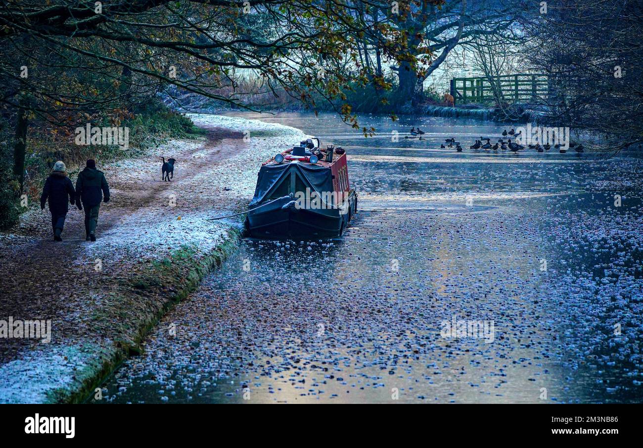 A moored canal boat on a frozen Bridgewater canal in Lymm, Cheshire ...