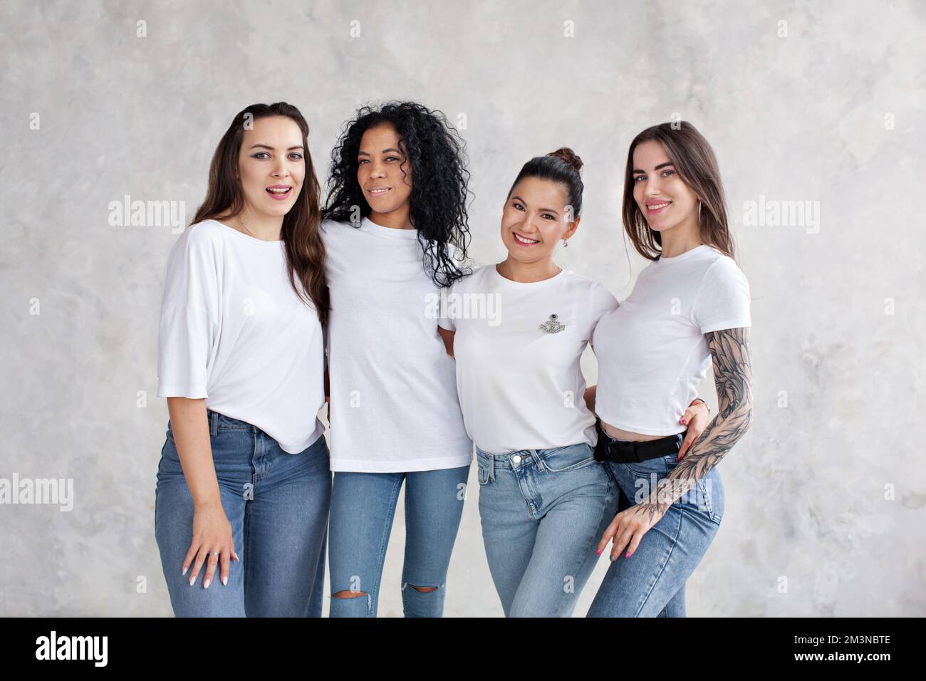 Portrait of beautiful young girls stand against wall background indoor ...