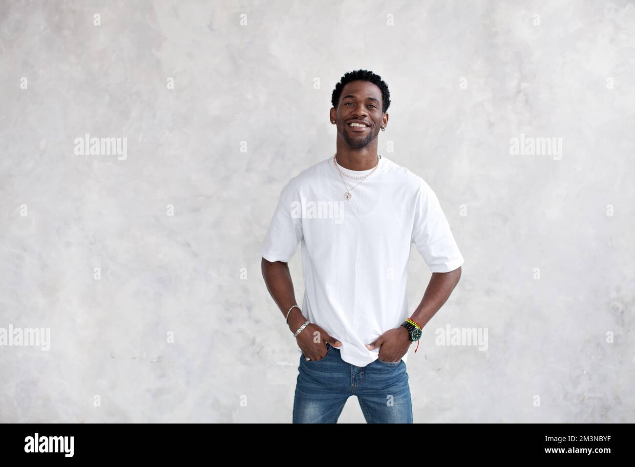 Portrait of smiling African American young man against bright textured ...