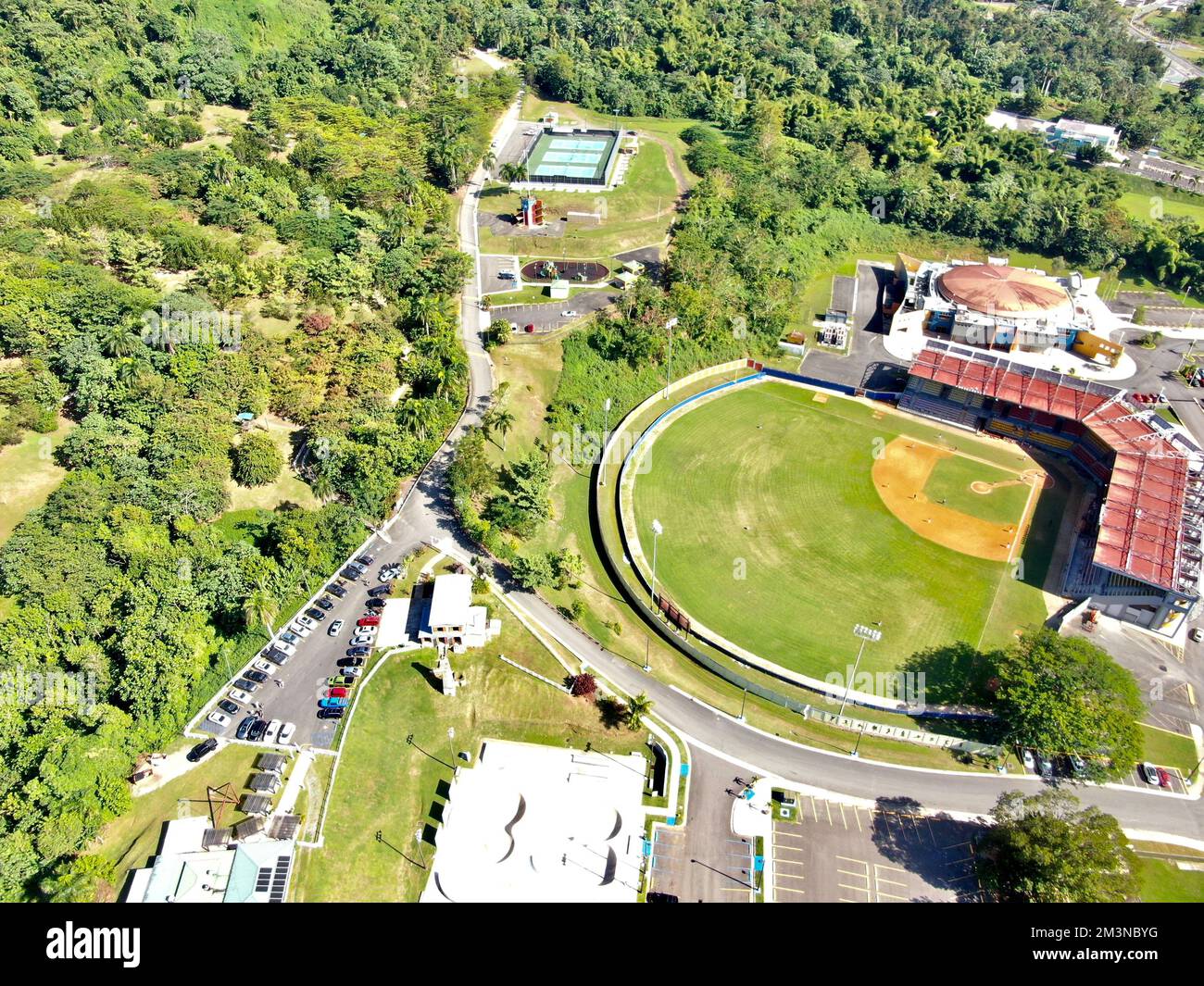 A drone view of a baseball field and a tennis court surrounded by the ...