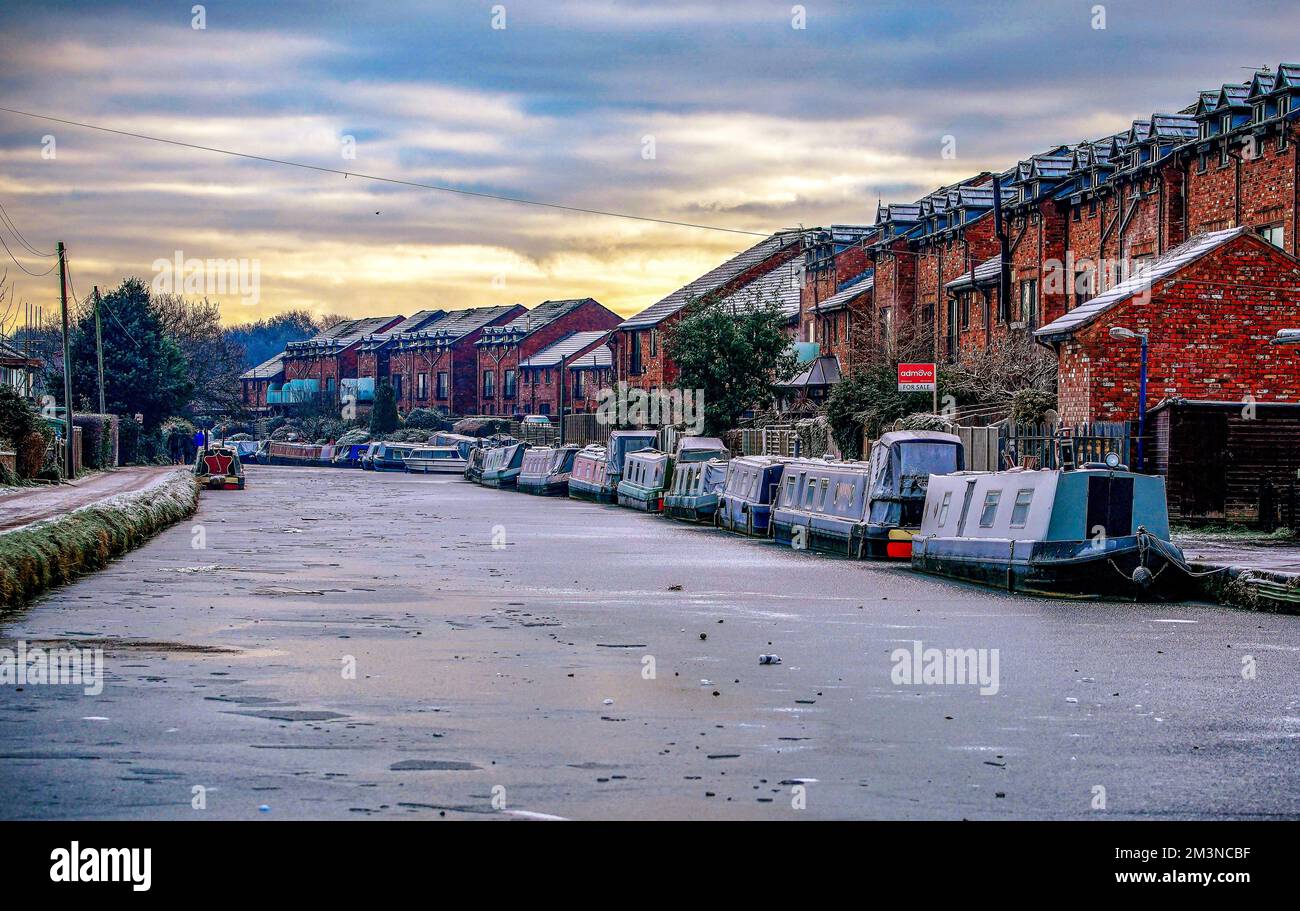 Moored canal boats on a frozen Bridgewater canal in Lymm, Cheshire ...