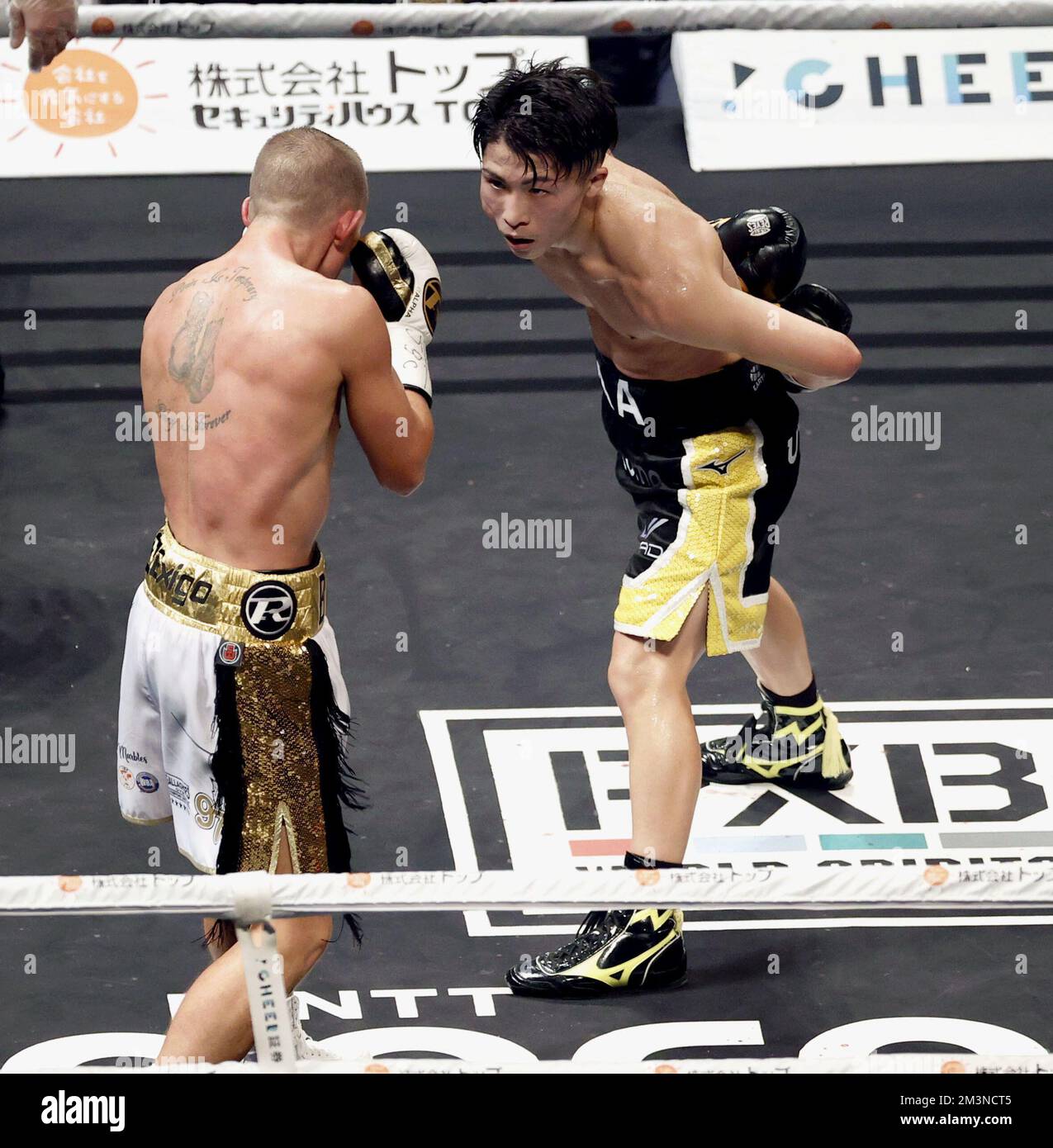 Japan's Naoya Inoue (R) puts his hands behind his back and sticks his ...